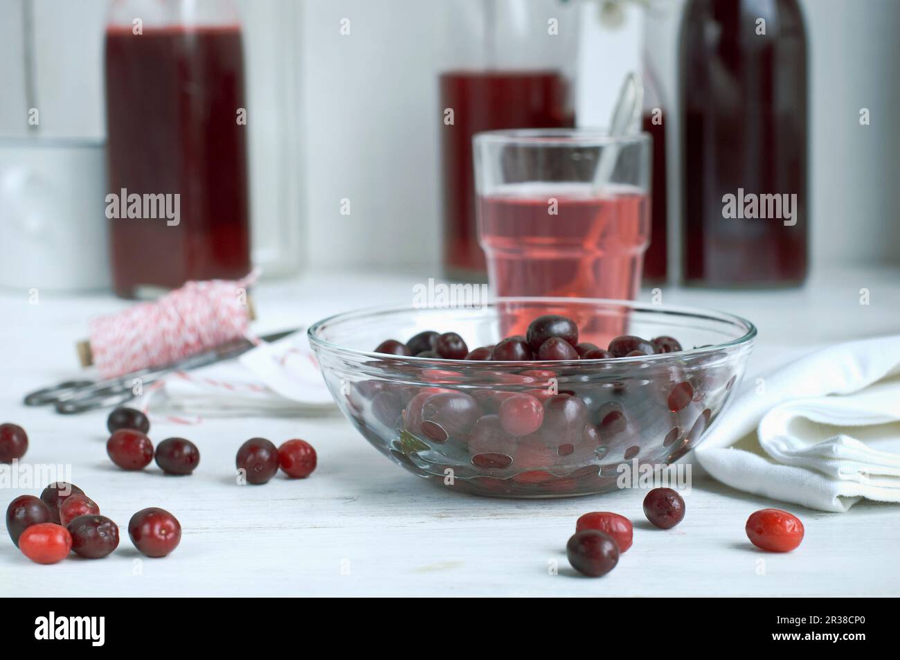 Cornelian cherries in a glass bowel and syrup in bottles Stock Photo ...