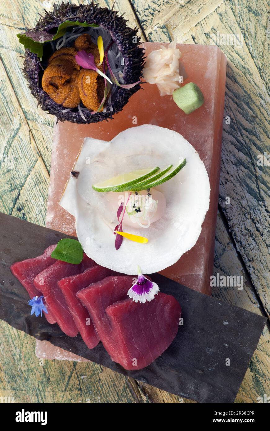 Tuna, scallop and sea urchin served on a pink salt brick (Japan Stock ...