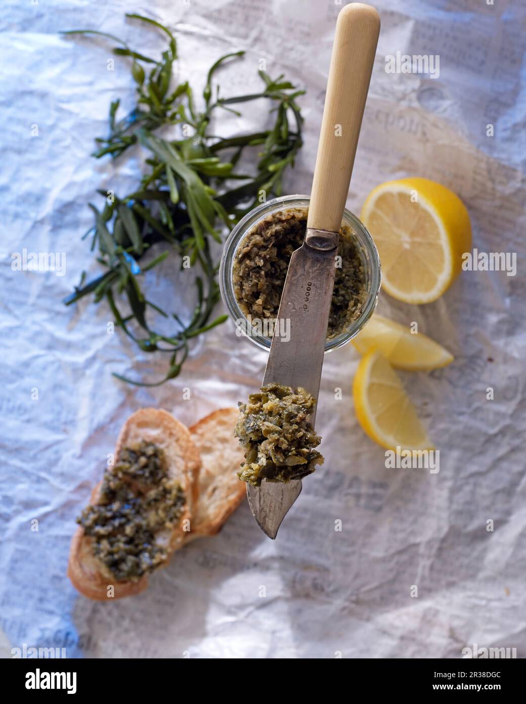 Algae tartare on a knife and in a glass jar, with baguette slices ...