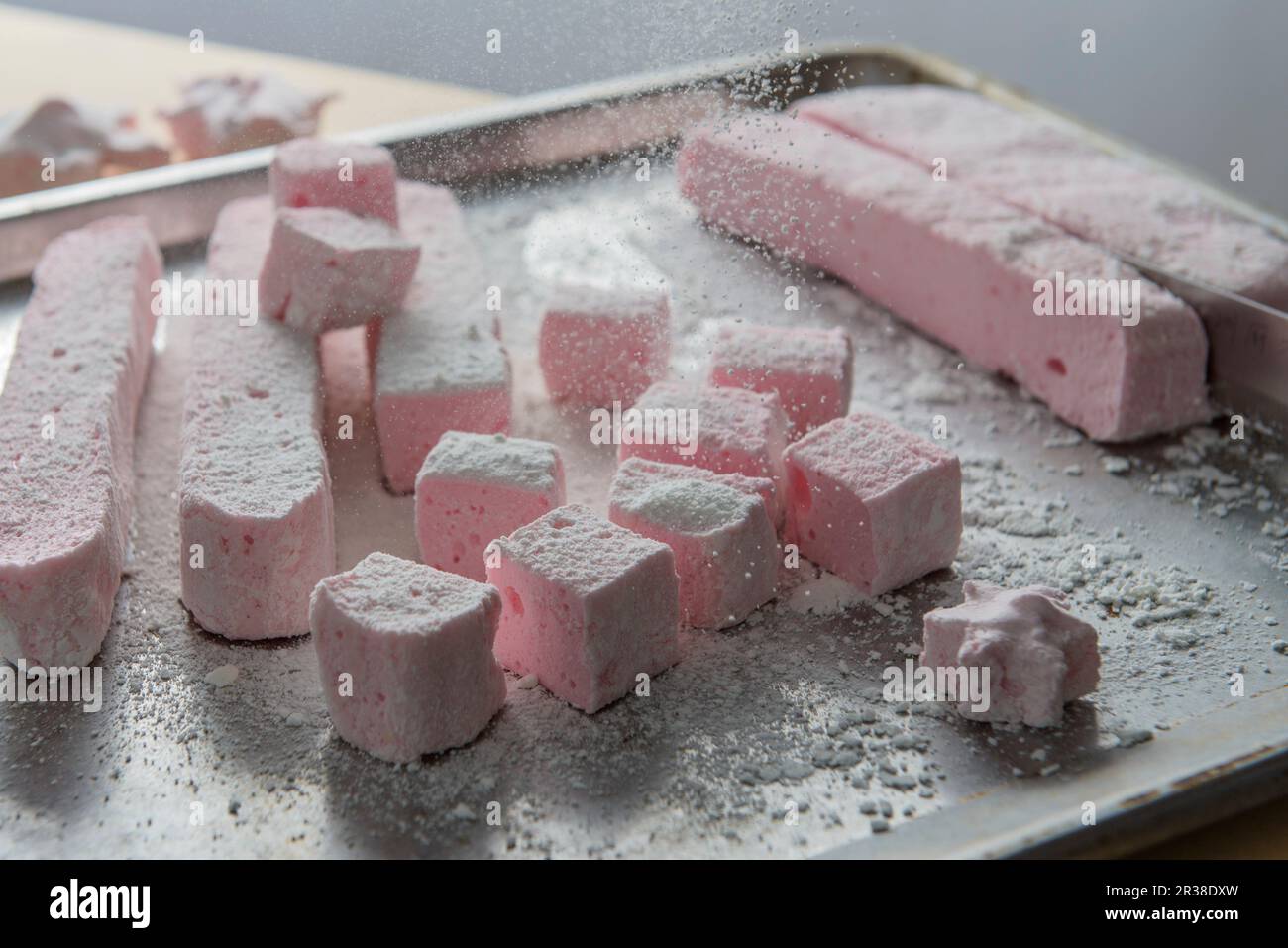 Marshmallows being dusted with icing sugar Stock Photo - Alamy