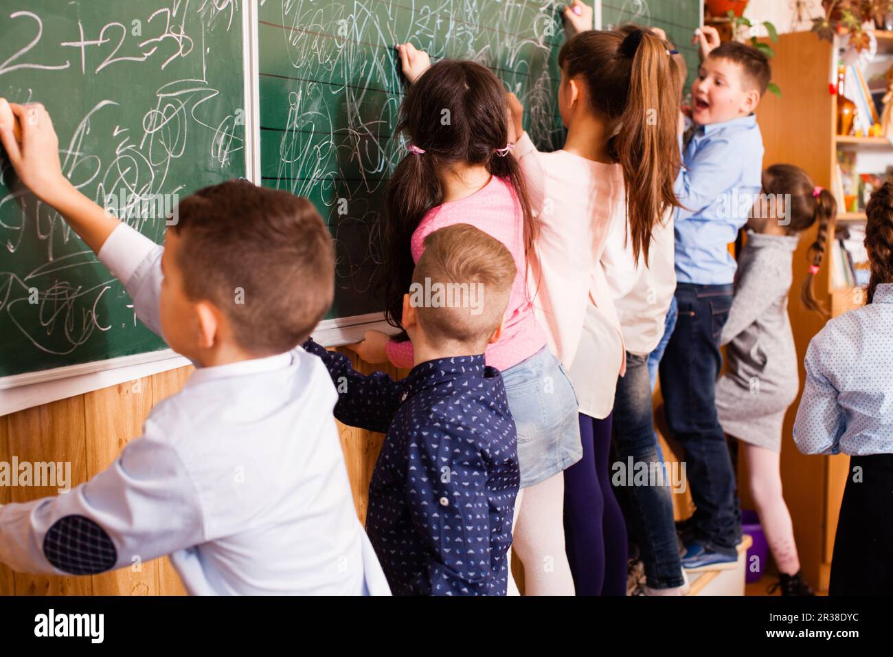 Classmates are drawing on a board during the break Stock Photo - Alamy