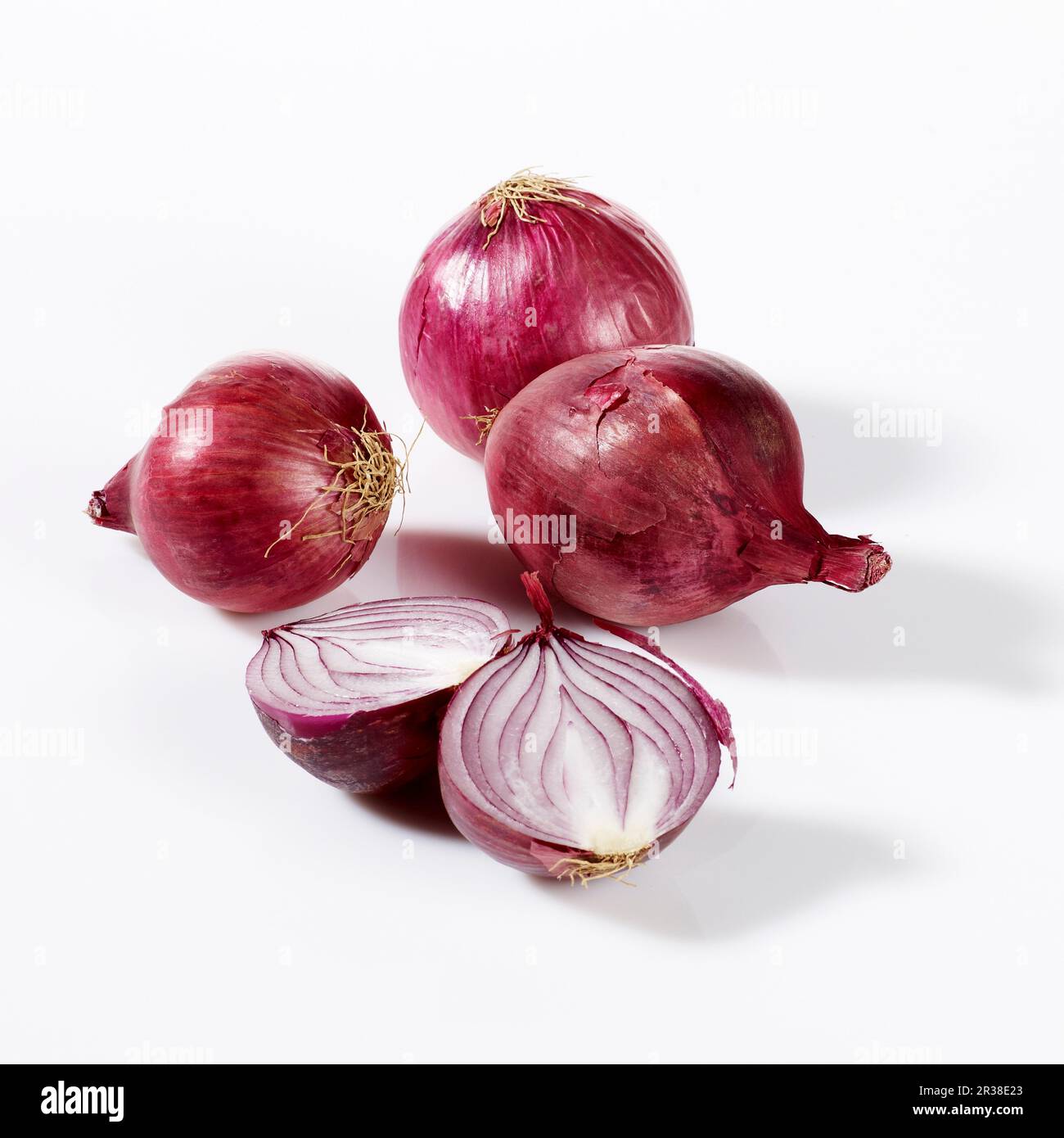 Four red onions, one halved Stock Photo - Alamy