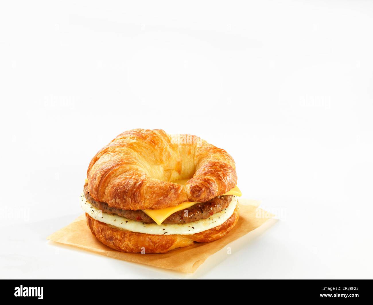A croissant burger with cheese and egg against a white background Stock ...