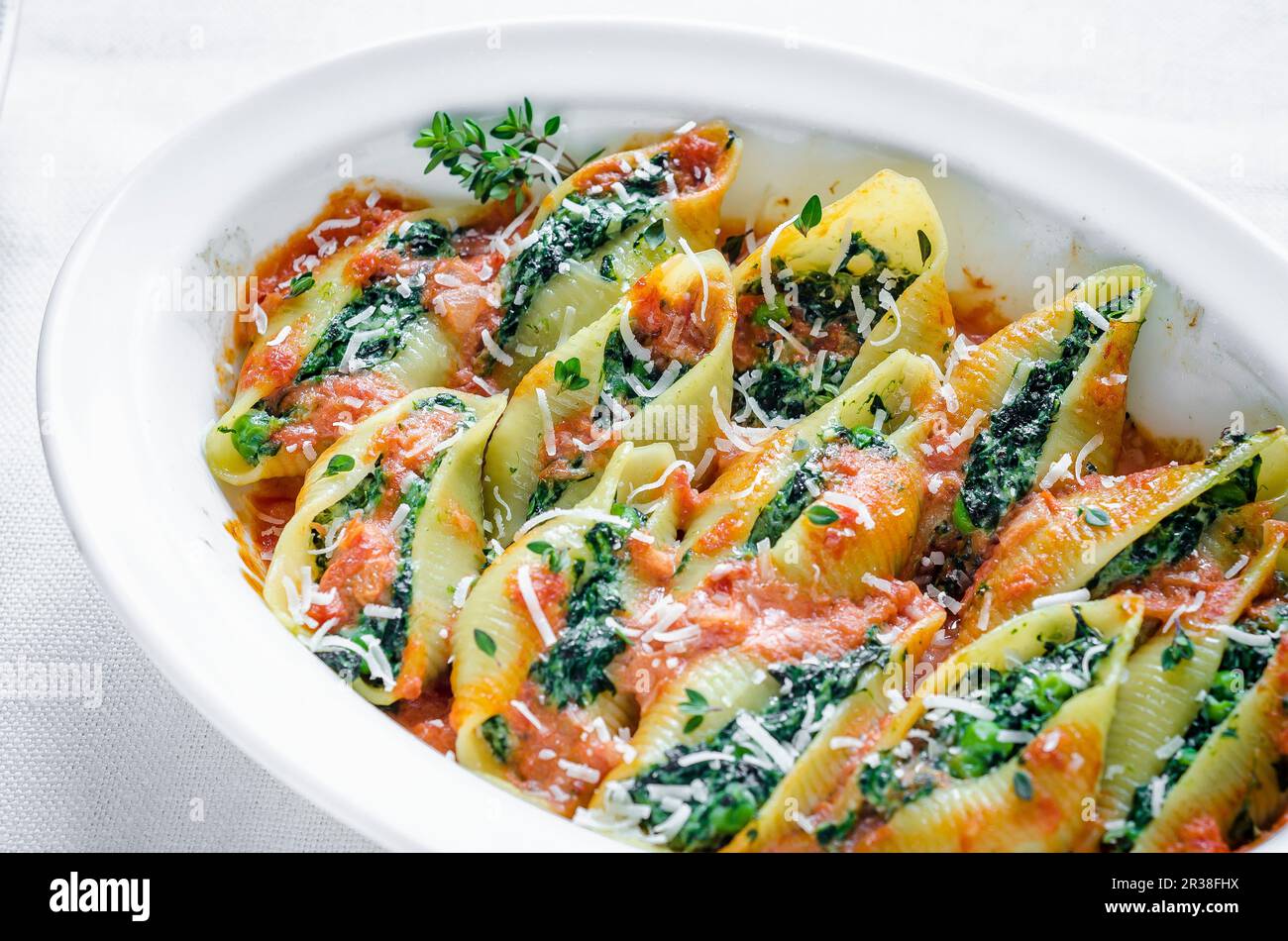 Shell pasta with a spinach-ricotta filling in tomato sauce with ...