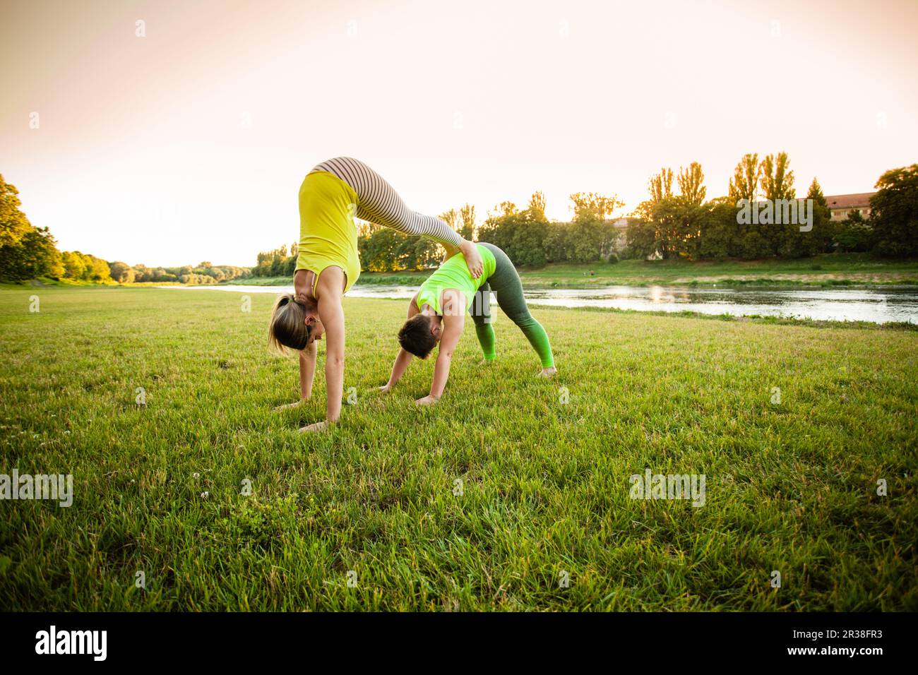 Two young beautiful women standing in acro yoga pose Stock Photo - Alamy