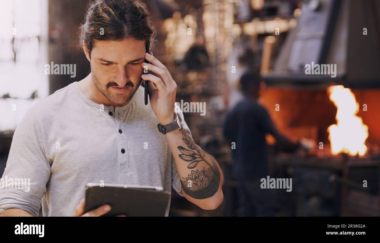 Tablet, phone call and a welding man in a plant for manufacturing ...