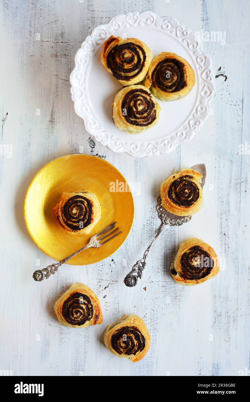 Poppy seed snails on a golden plate with a cake fork Stock Photo - Alamy