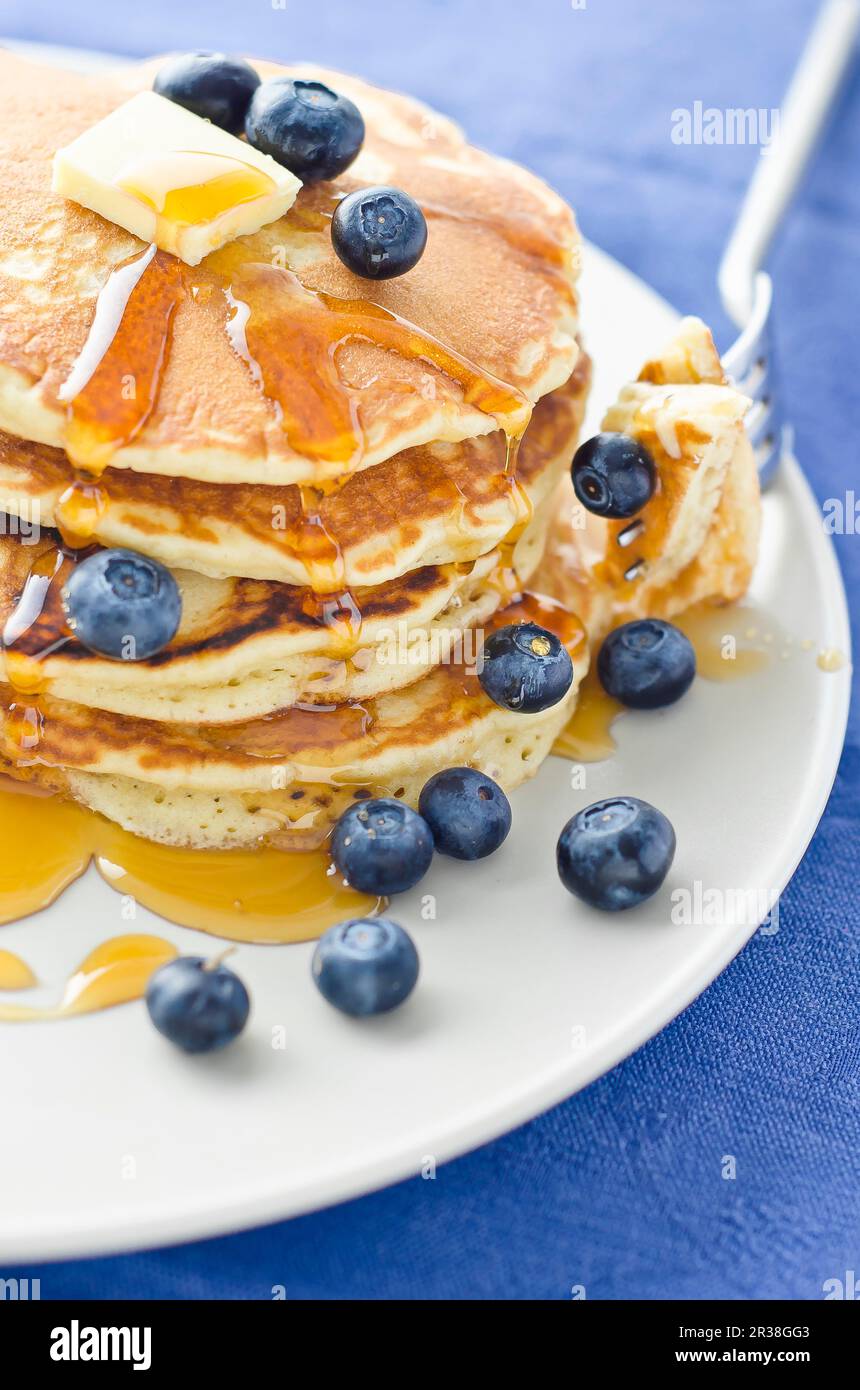 A Stack of Three Blueberry Pancakes with Maple Syrup and Orange Juice ...