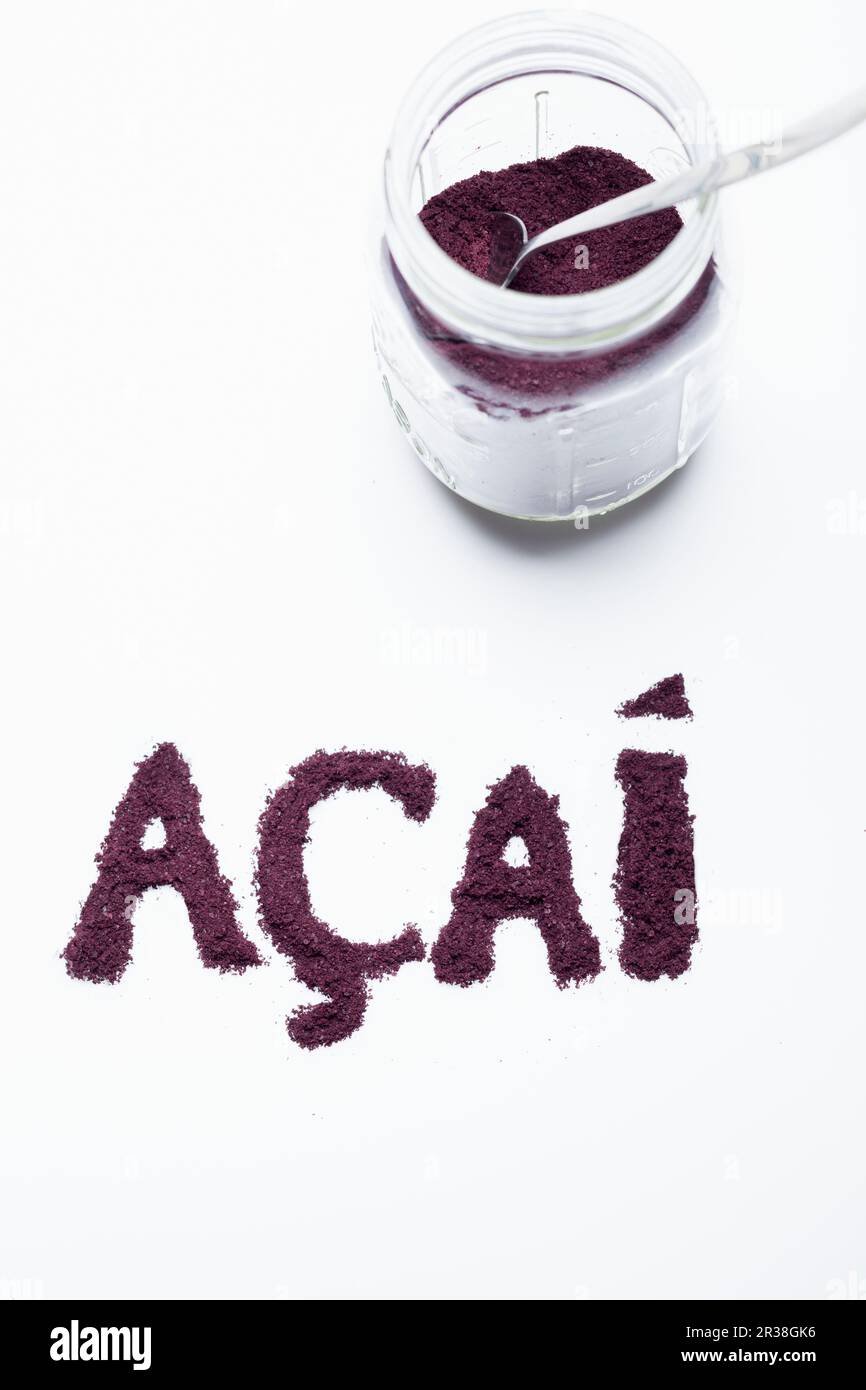 Acai berry powder: in a glass jar and lettered against a white ...
