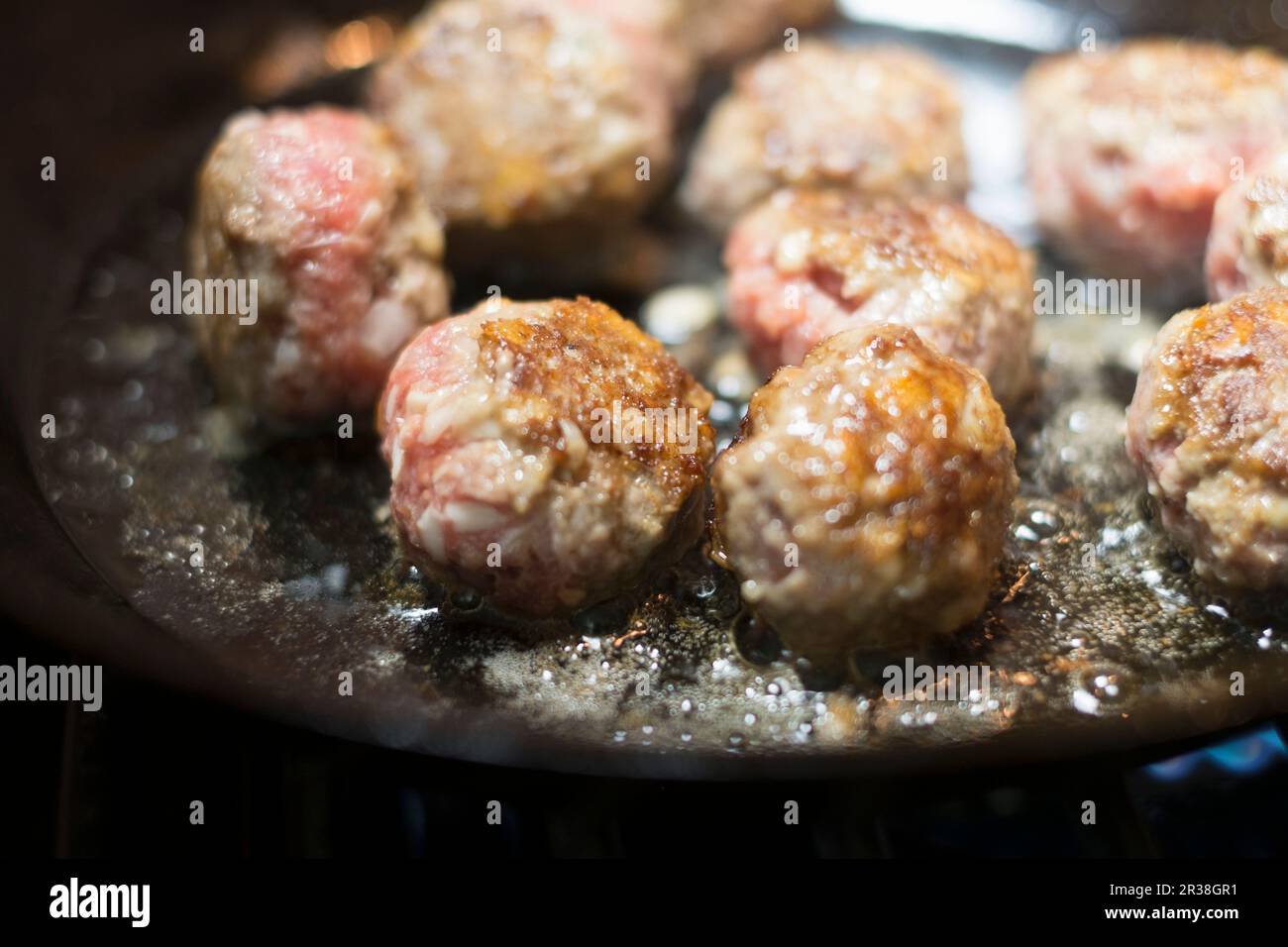 Meatballs being fried in a pan Stock Photo - Alamy