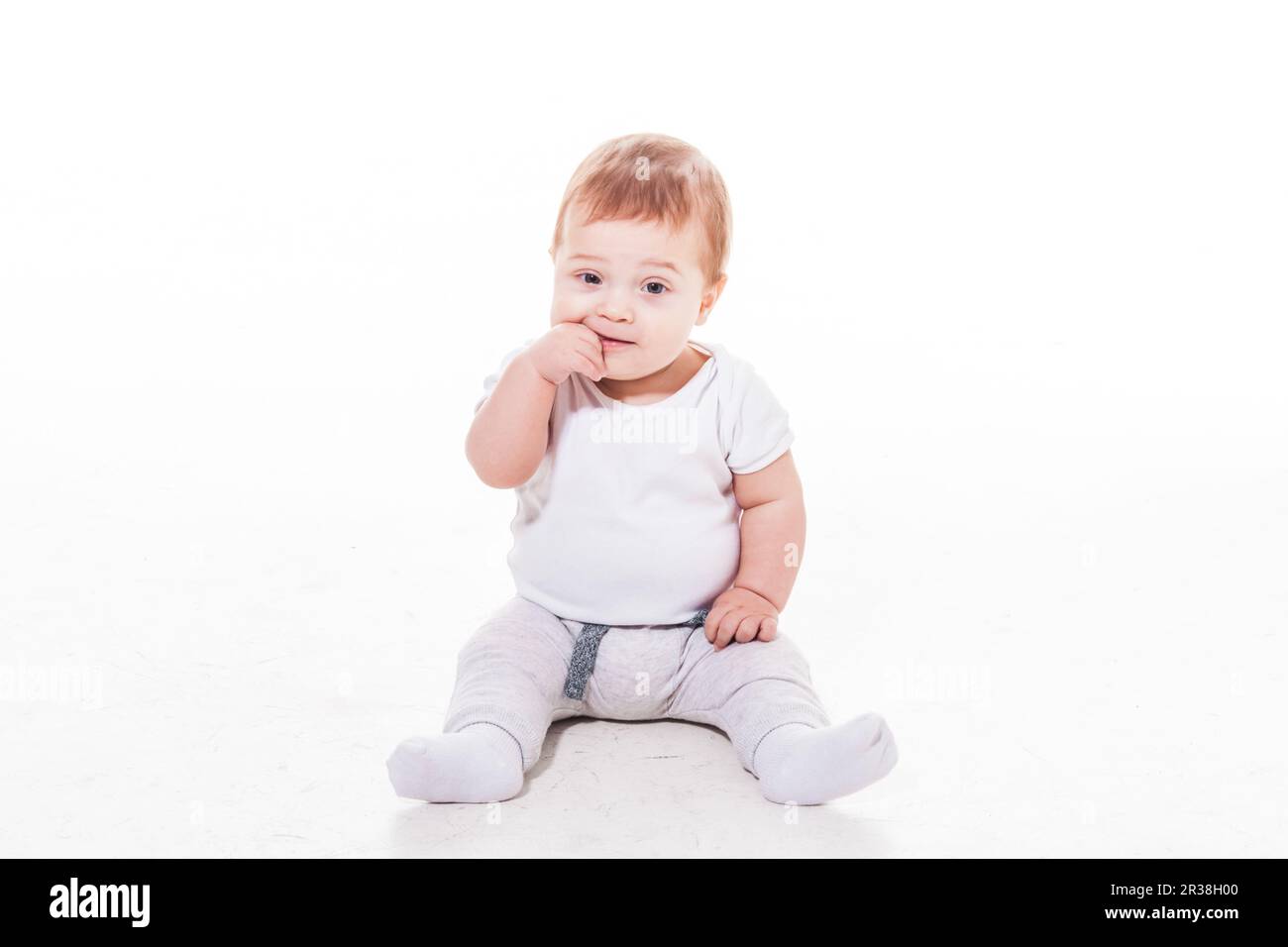 Smiling baby sitting on a floor Stock Photo - Alamy