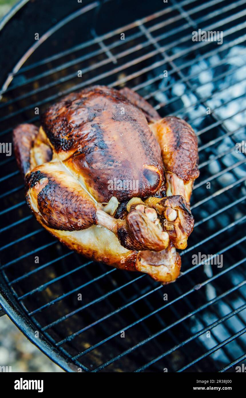 A whole chicken on a barbecue rack Stock Photo - Alamy