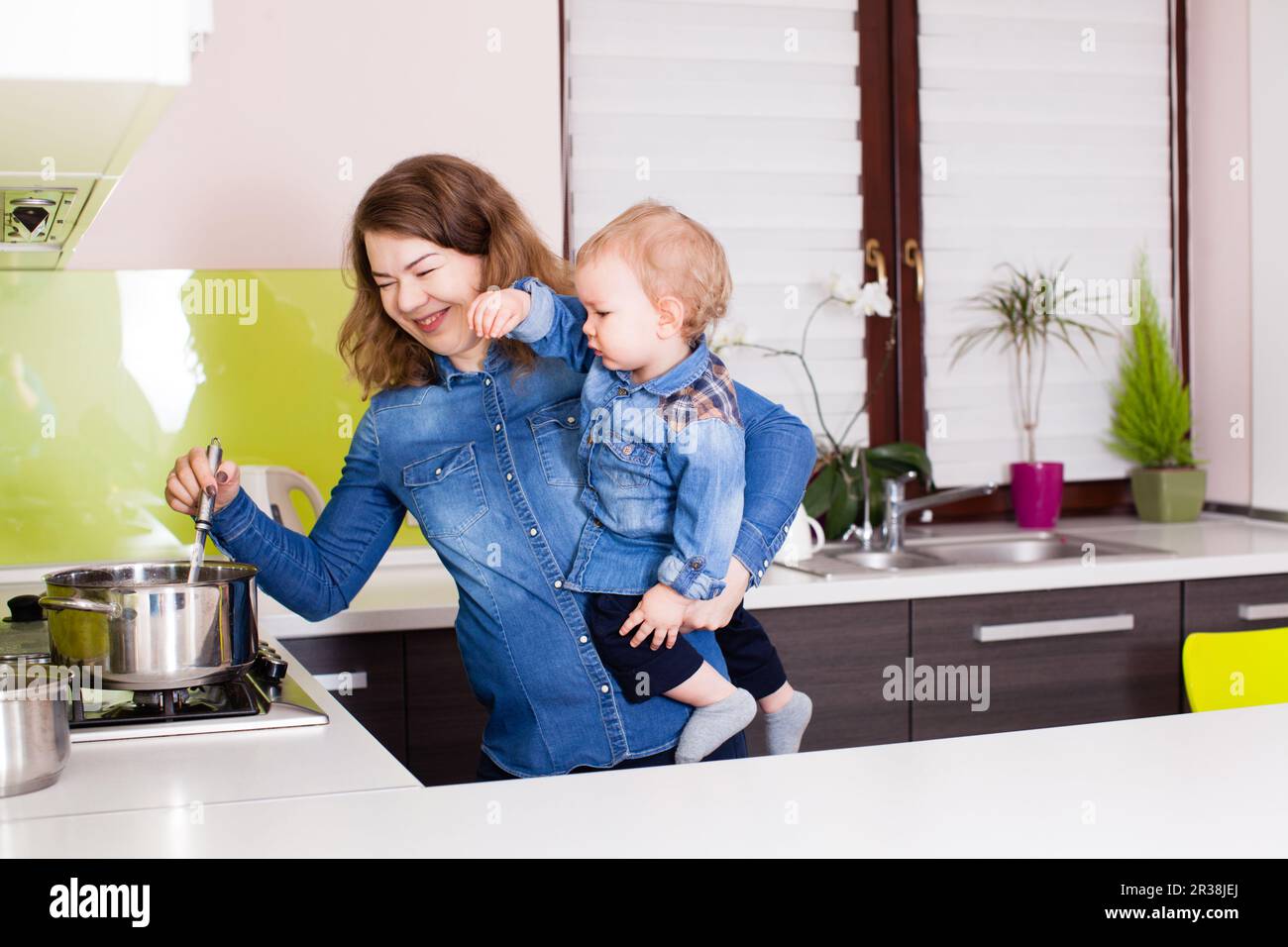Young mother teach small baby boy to cook Stock Photo - Alamy