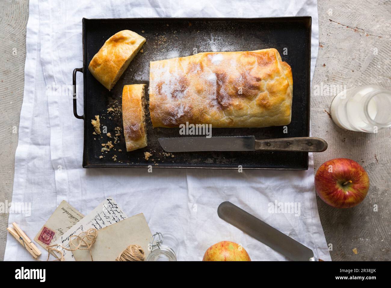 Apple strudel dusted with icing sugar, cut open Stock Photo - Alamy