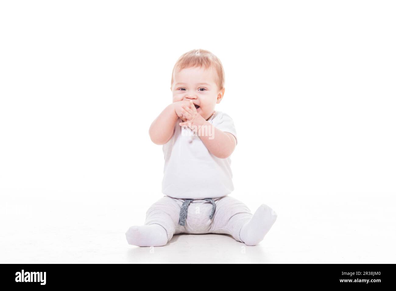 Smiling baby sitting on a floor Stock Photo - Alamy