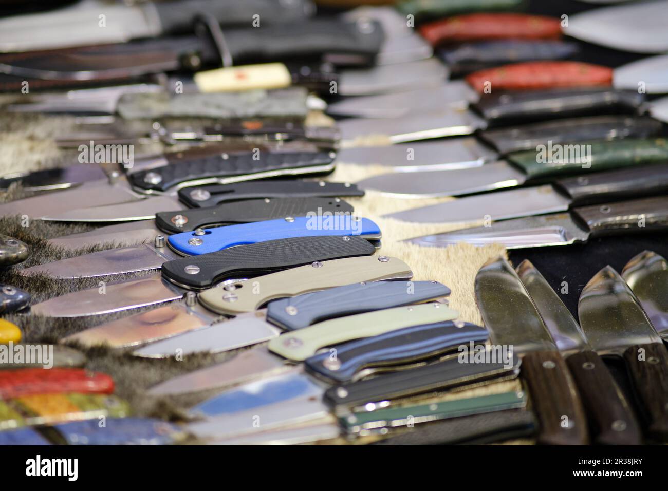Various military knives are present on the desk, and the store carries ...