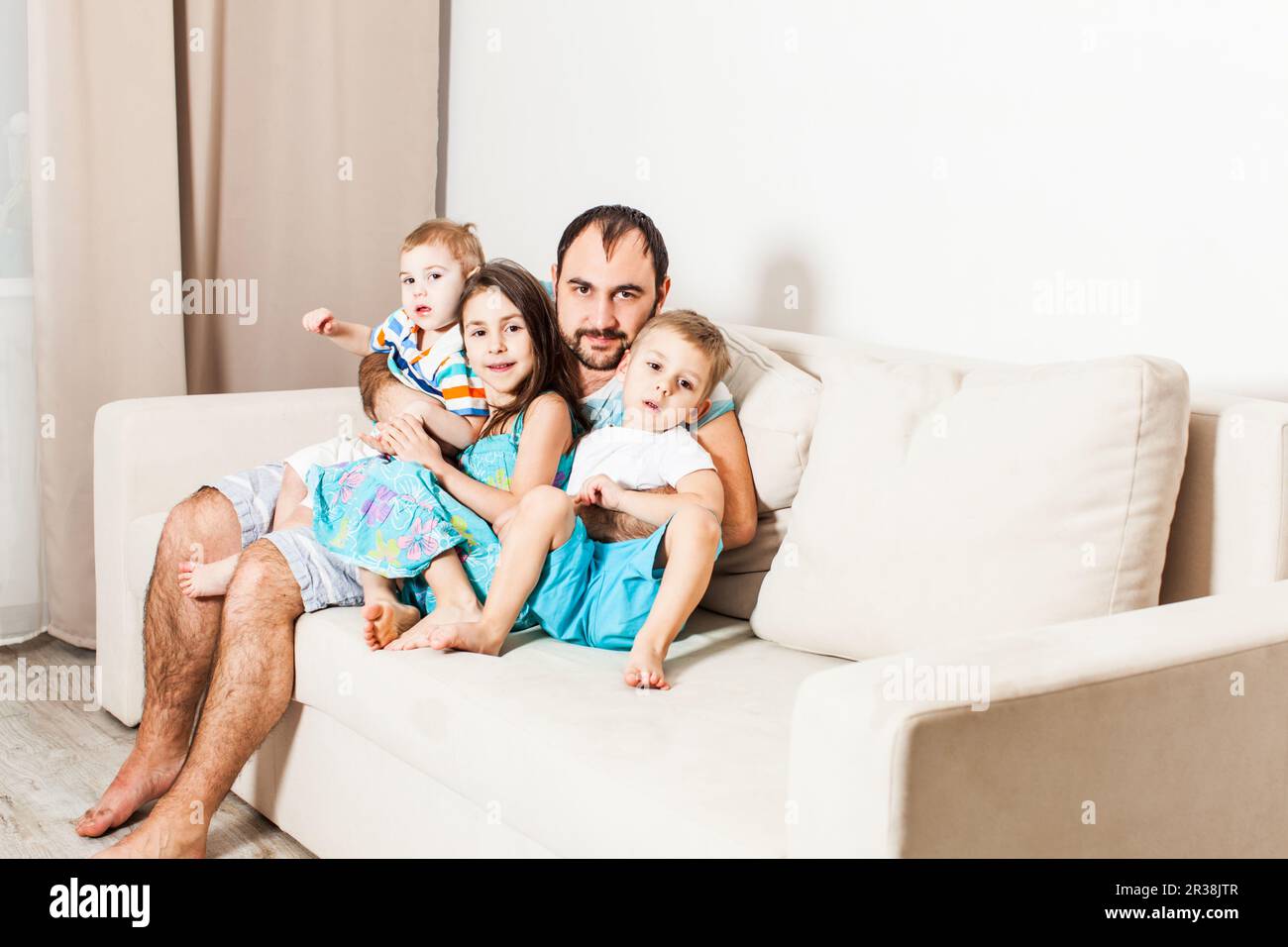 Young man embracing children. Portrait of a caring father Stock Photo ...