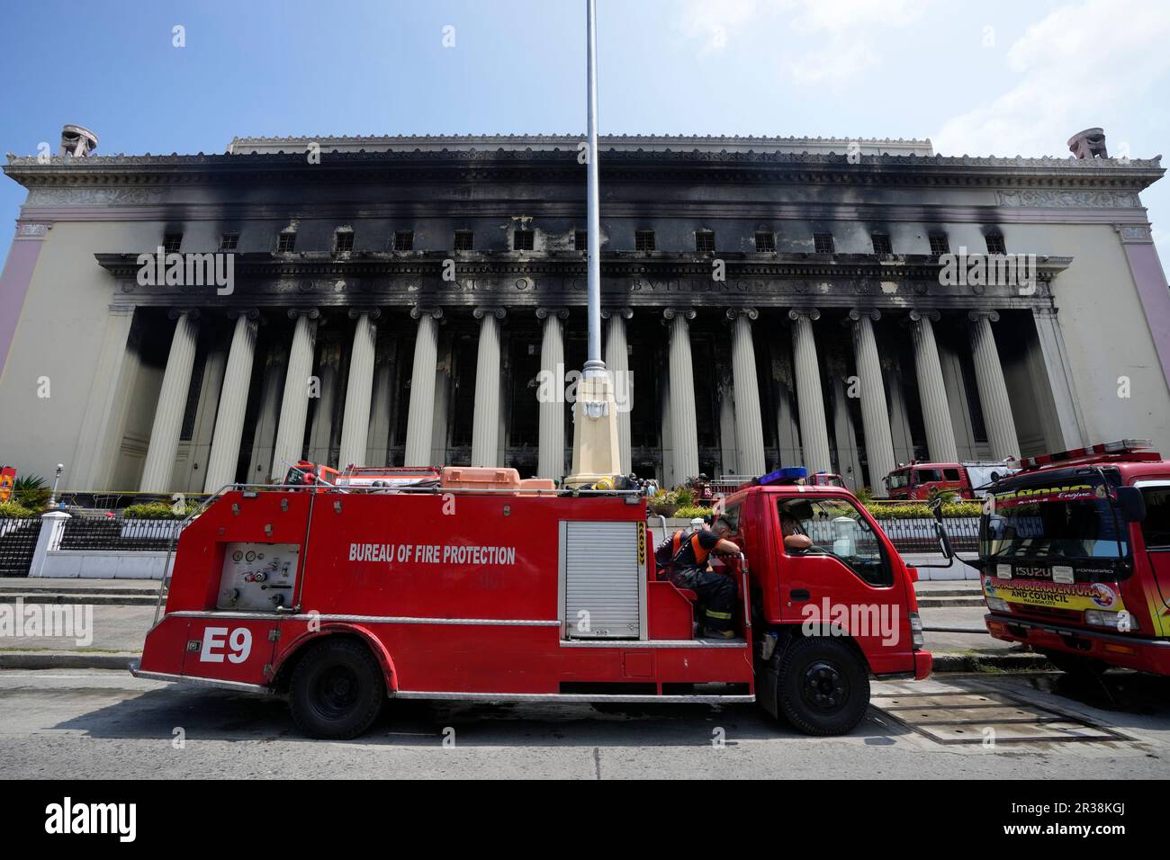 Firemen rest outside the burned Manila Post Office on Tuesday, May 23 ...