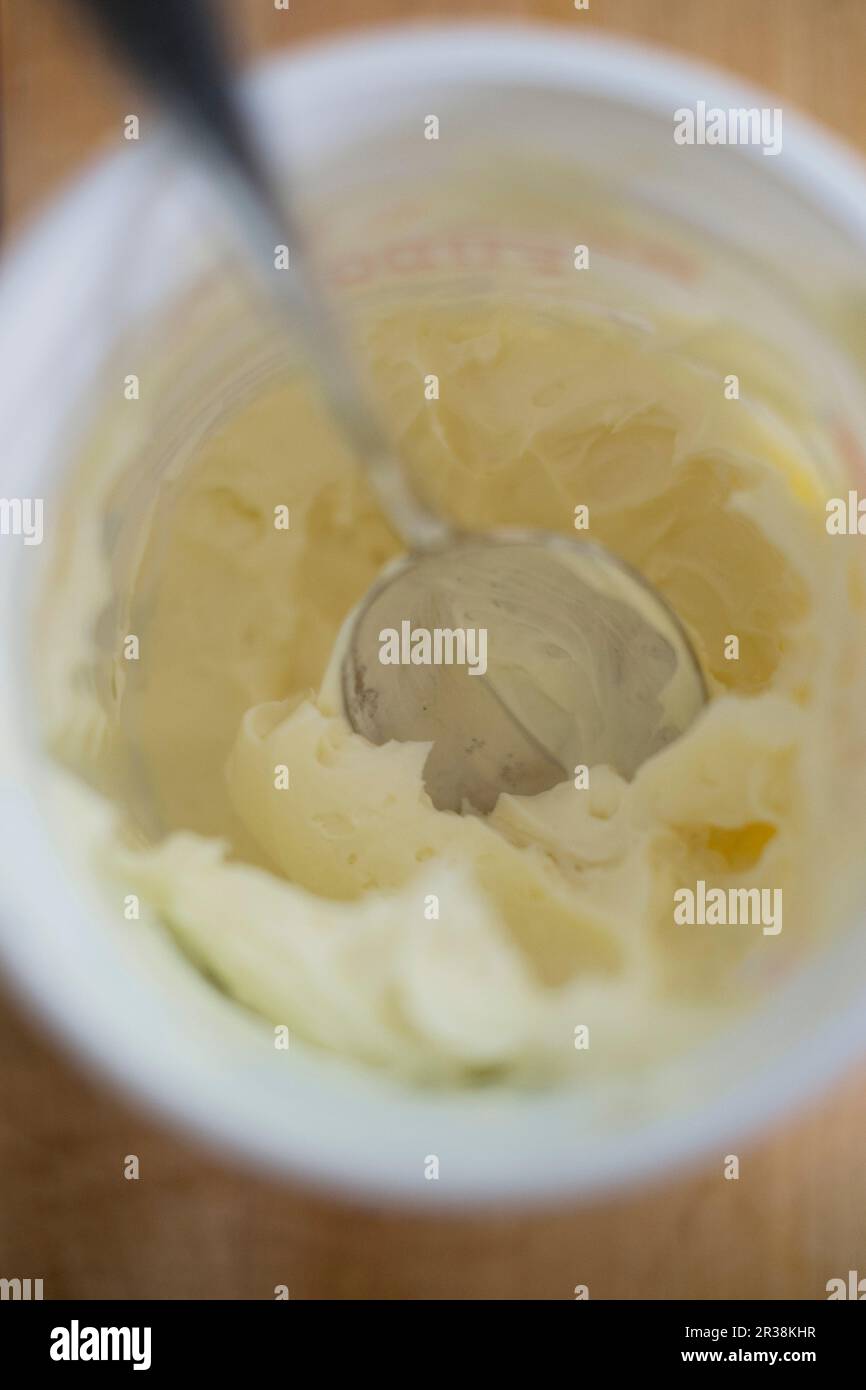 Cream cheese icing in a cup with a spoon Stock Photo - Alamy