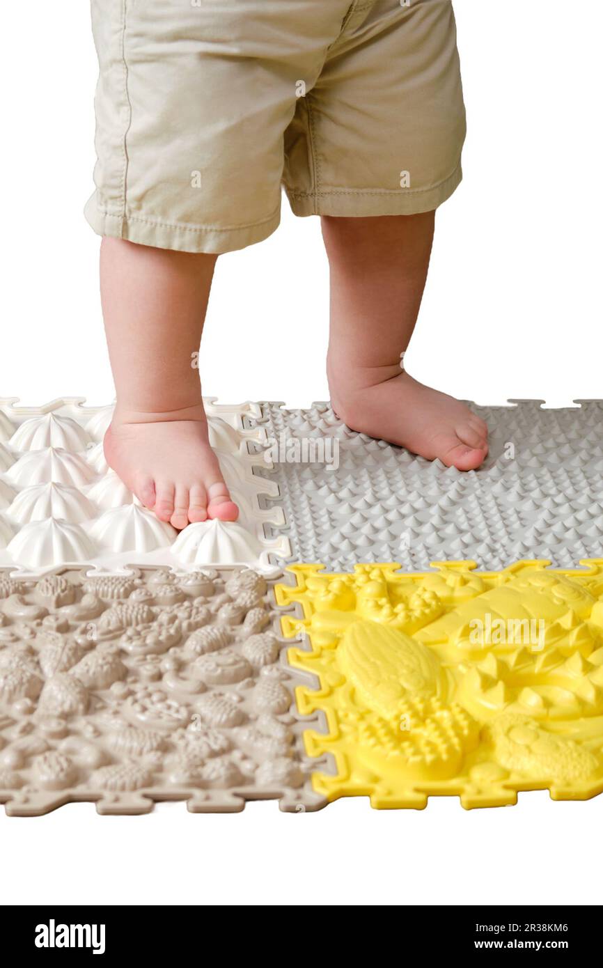 Baby toddler foots close-up on a medical orthopedic mat, isolated on ...
