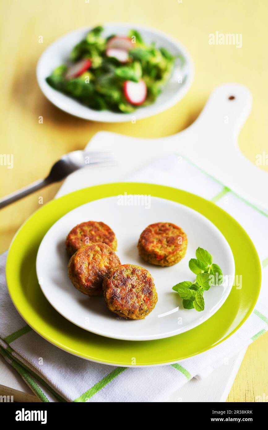 Small vegetable patties with a plate of salad Stock Photo - Alamy