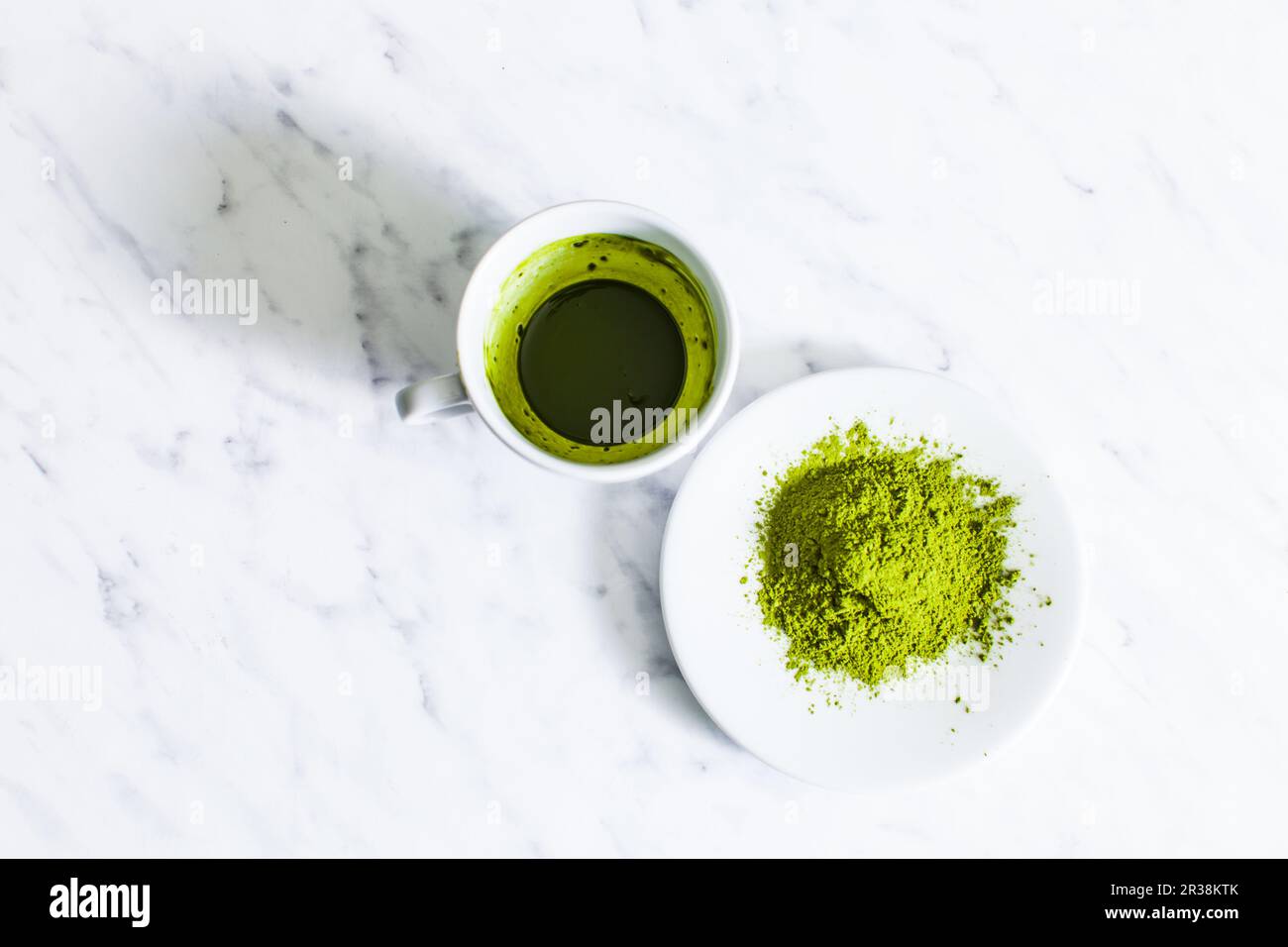 A cup of green matcha tea with matcha powder tea isolated on a light ...