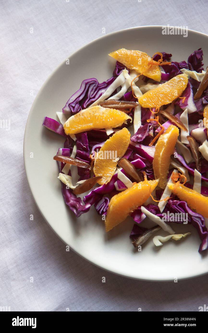 A raw and healthy winter salad ith red cabbage, white cabbage, dates ...