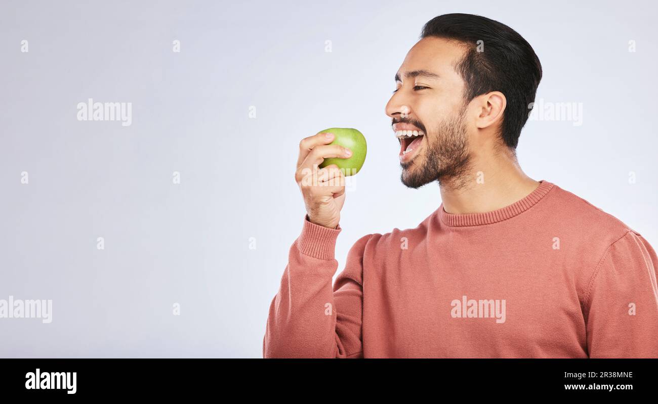 Green apple, eating and happy man isolated on a white background for ...