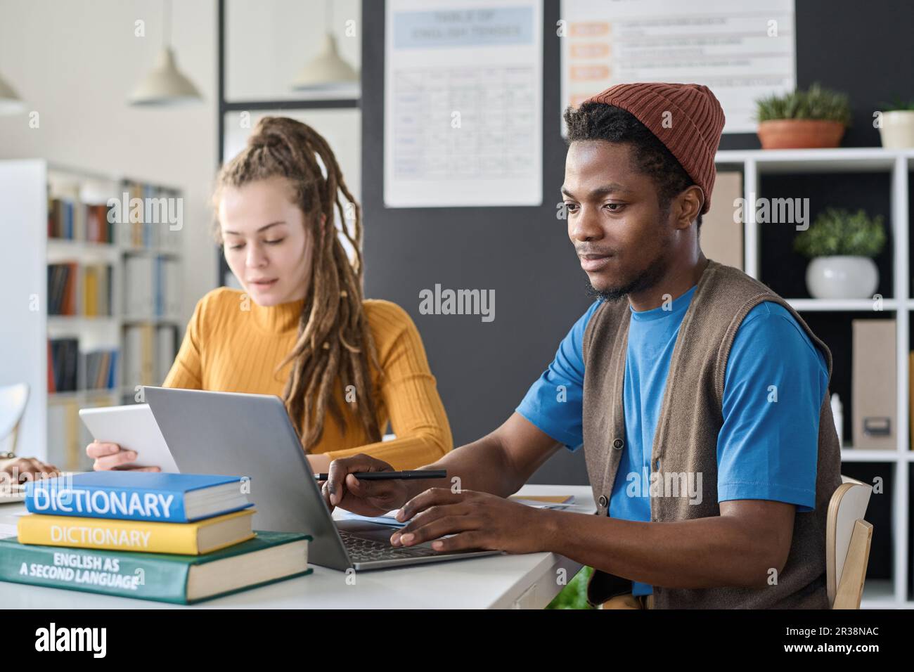 African American student doing task online on laptop while studying in ...