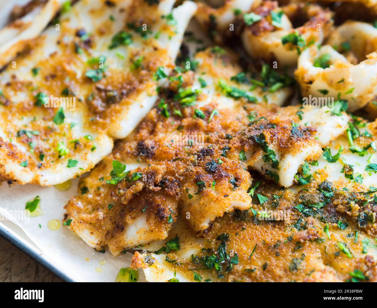 Grilled breaded cuttlefish with parsley Stock Photo - Alamy