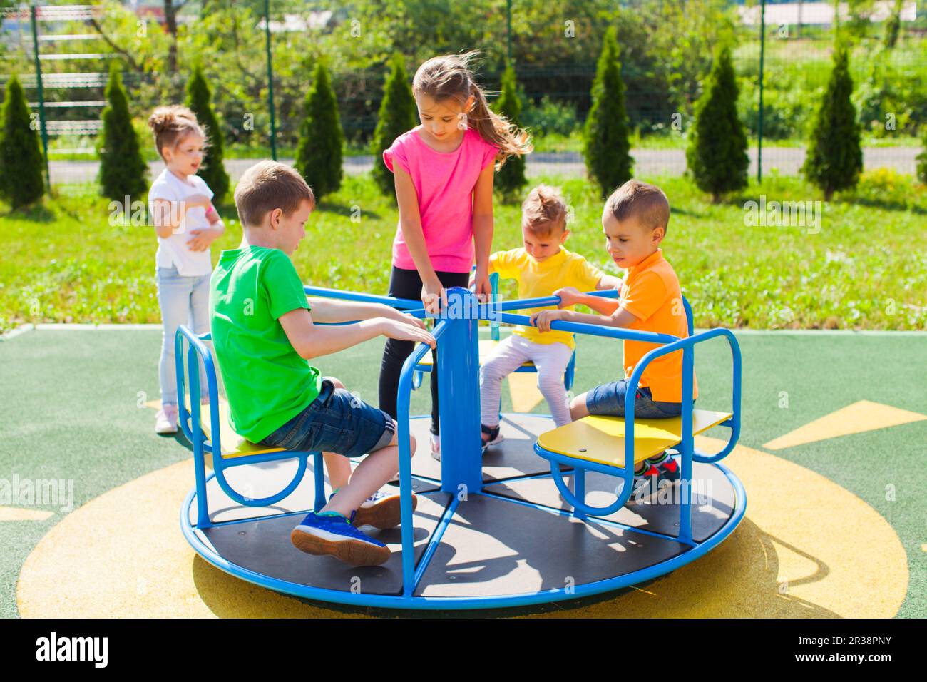 The kids spin the carousel in turn Stock Photo - Alamy
