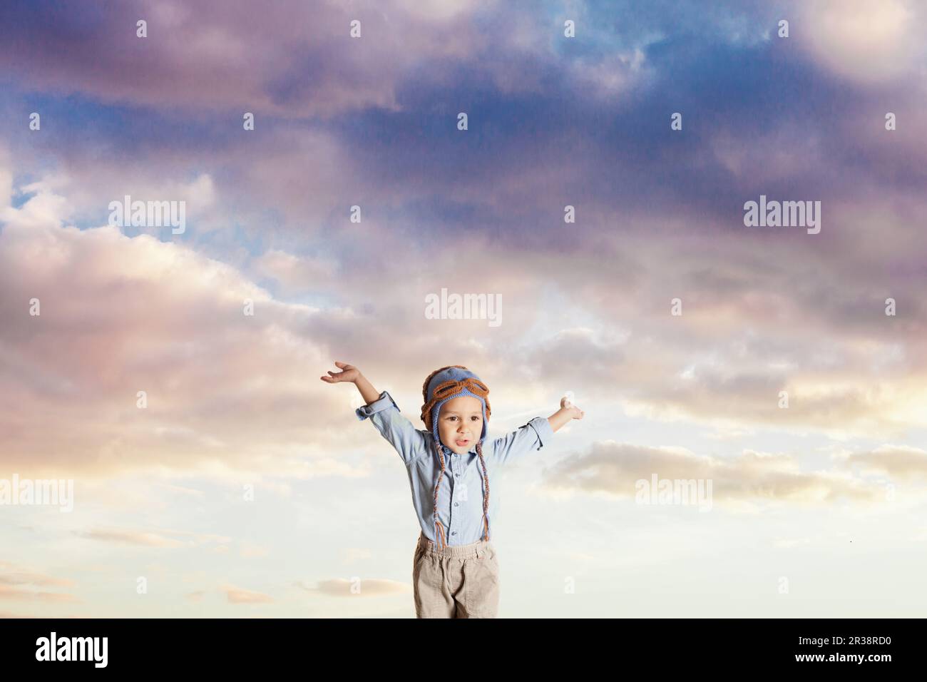 Kid pretending flying on a cloudy sky background Stock Photo - Alamy