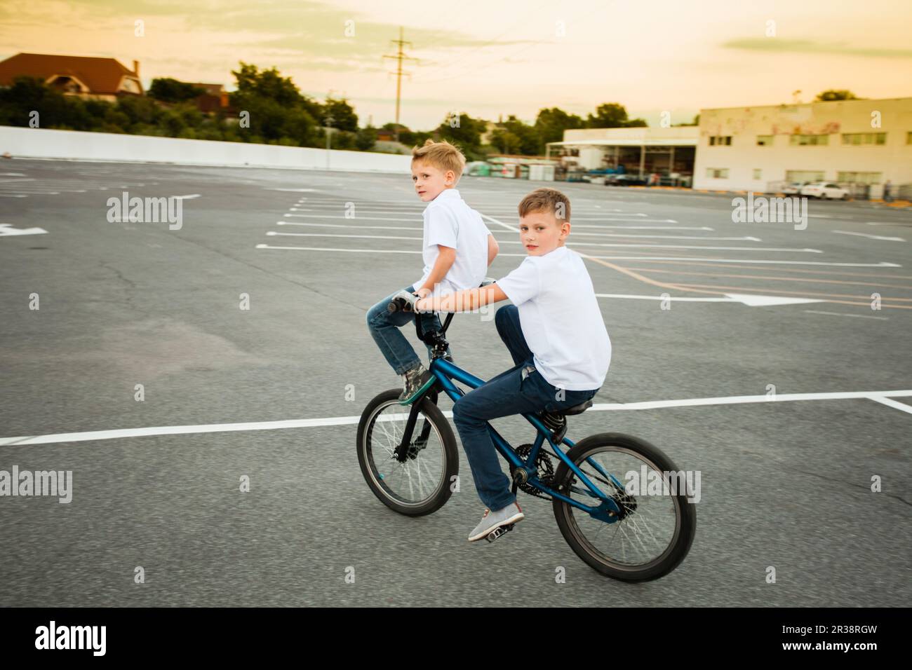 Two brothers showing their skills riding on one bike Stock Photo - Alamy