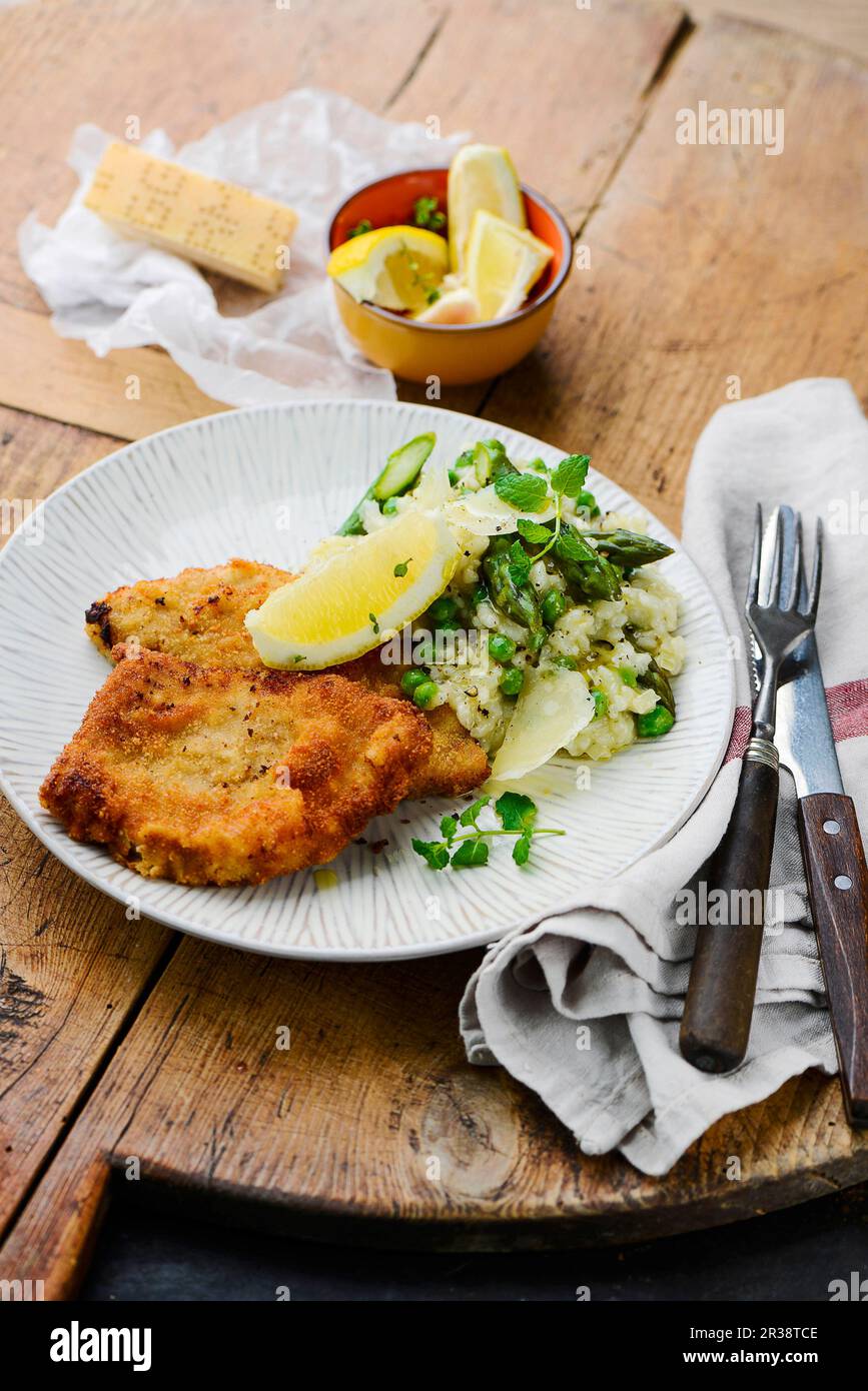 Breaded pork schnitzel with spring risotto Stock Photo - Alamy