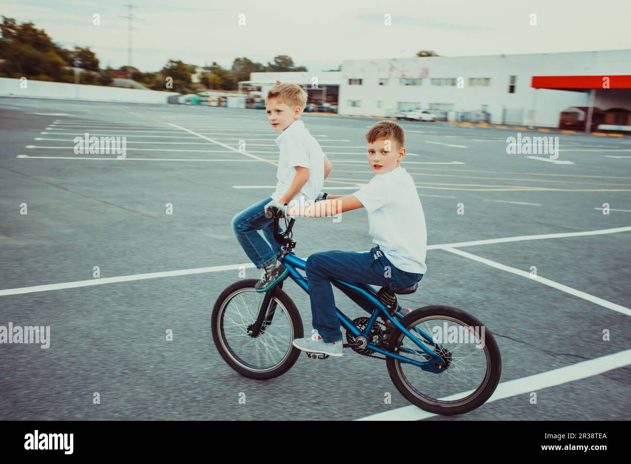 Brothers making tricks riding on one bike together Stock Photo - Alamy