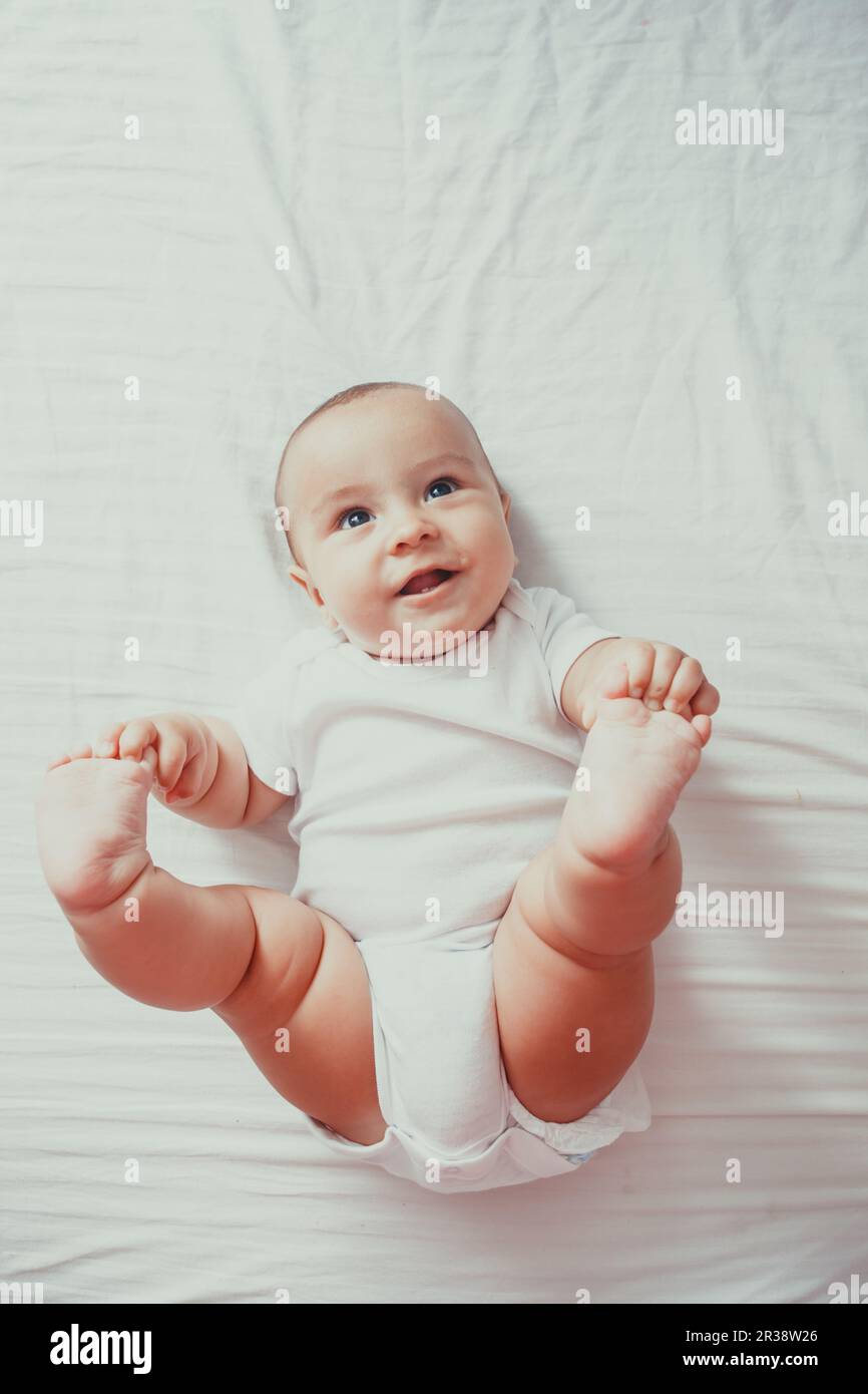 Baby lying on soft bed hi-res stock photography and images - Alamy