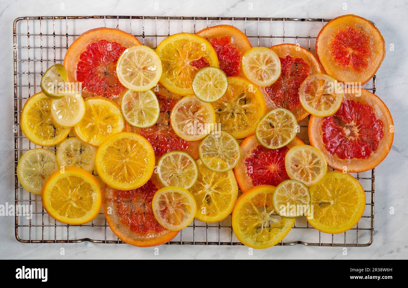 Citrus fruit slices cooked in syrup, on a drip tray (top view Stock ...
