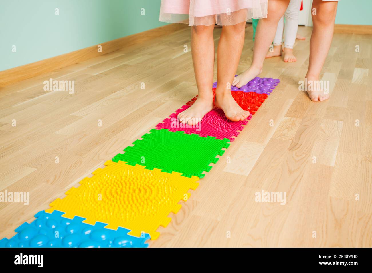 Closeup of kid feet while standing on special massaging mat Stock Photo ...
