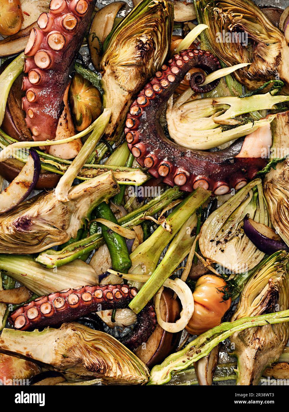 Oven-baked octopus with artichokes, tomatoes and fennel Stock Photo - Alamy