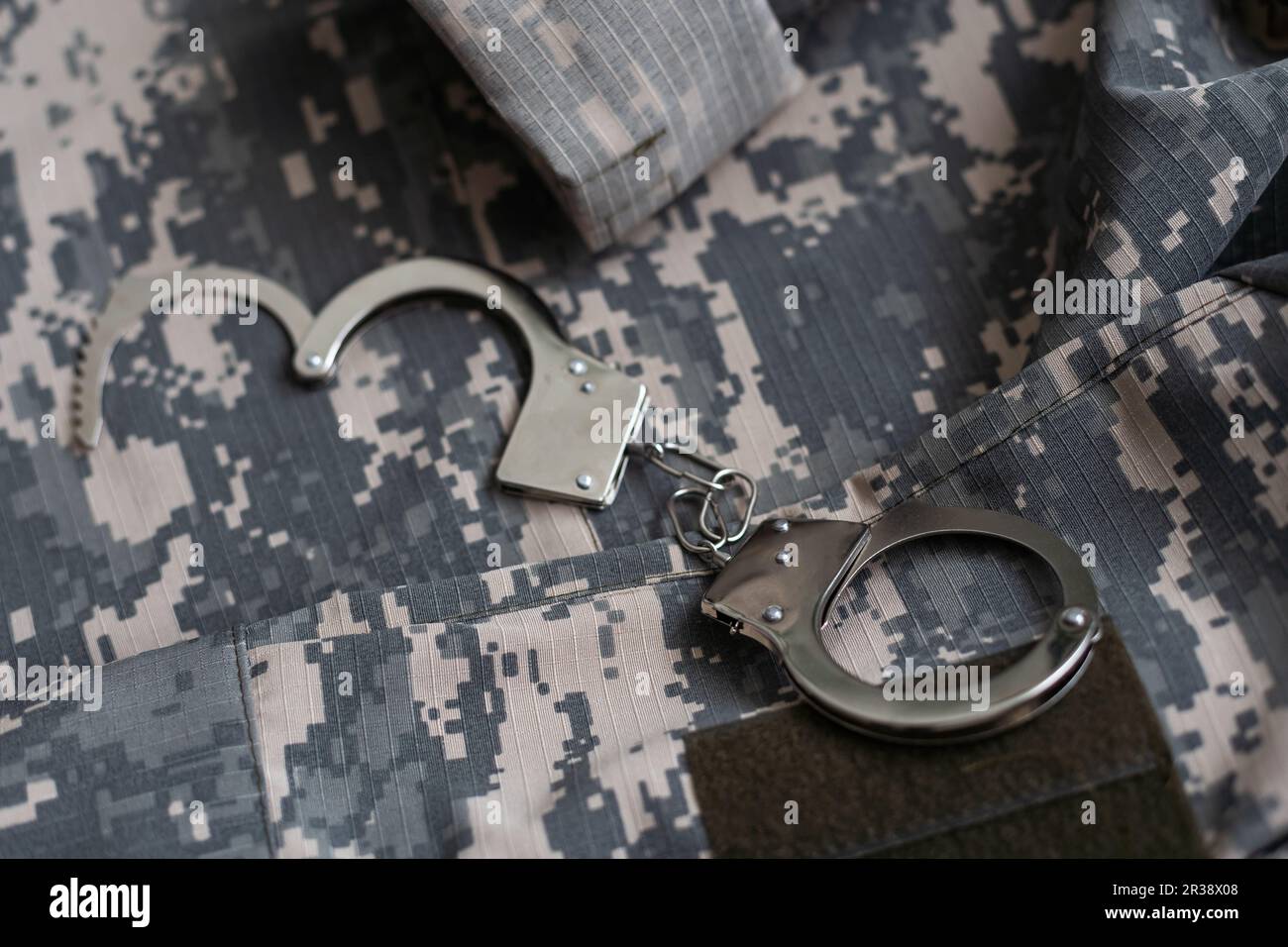 Handcuffs on a Camouflage background. Metal shackles isolated. Law ...