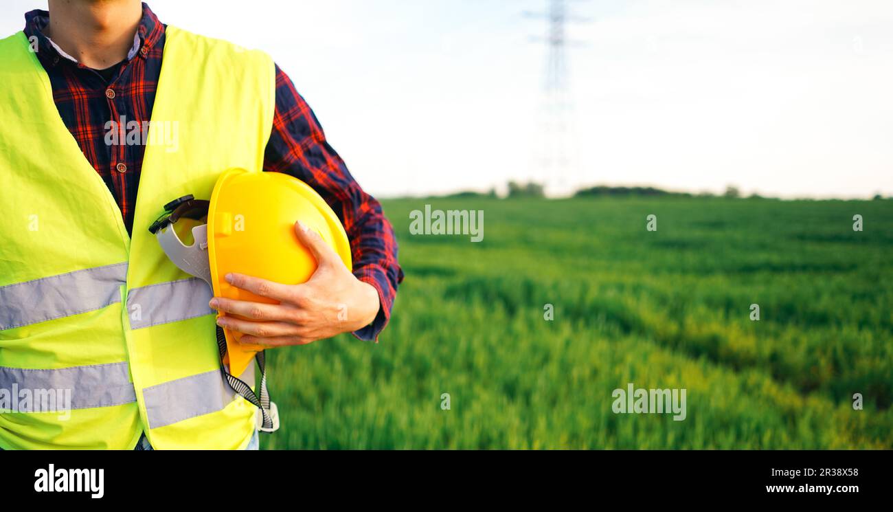 Construction worker holding yellow hard hat and wearing yellow ...