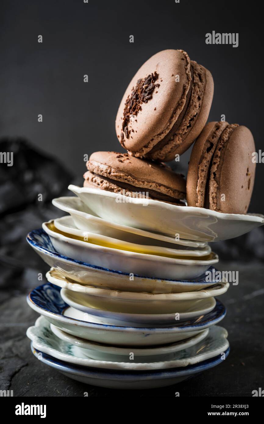 Three chocolate macaroons on a stack of plates Stock Photo - Alamy