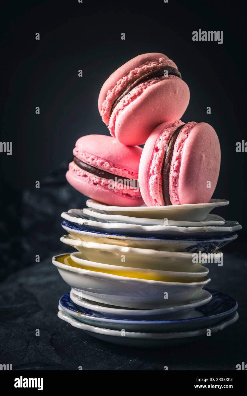 Three raspberry macaroons on a stack of plates Stock Photo - Alamy