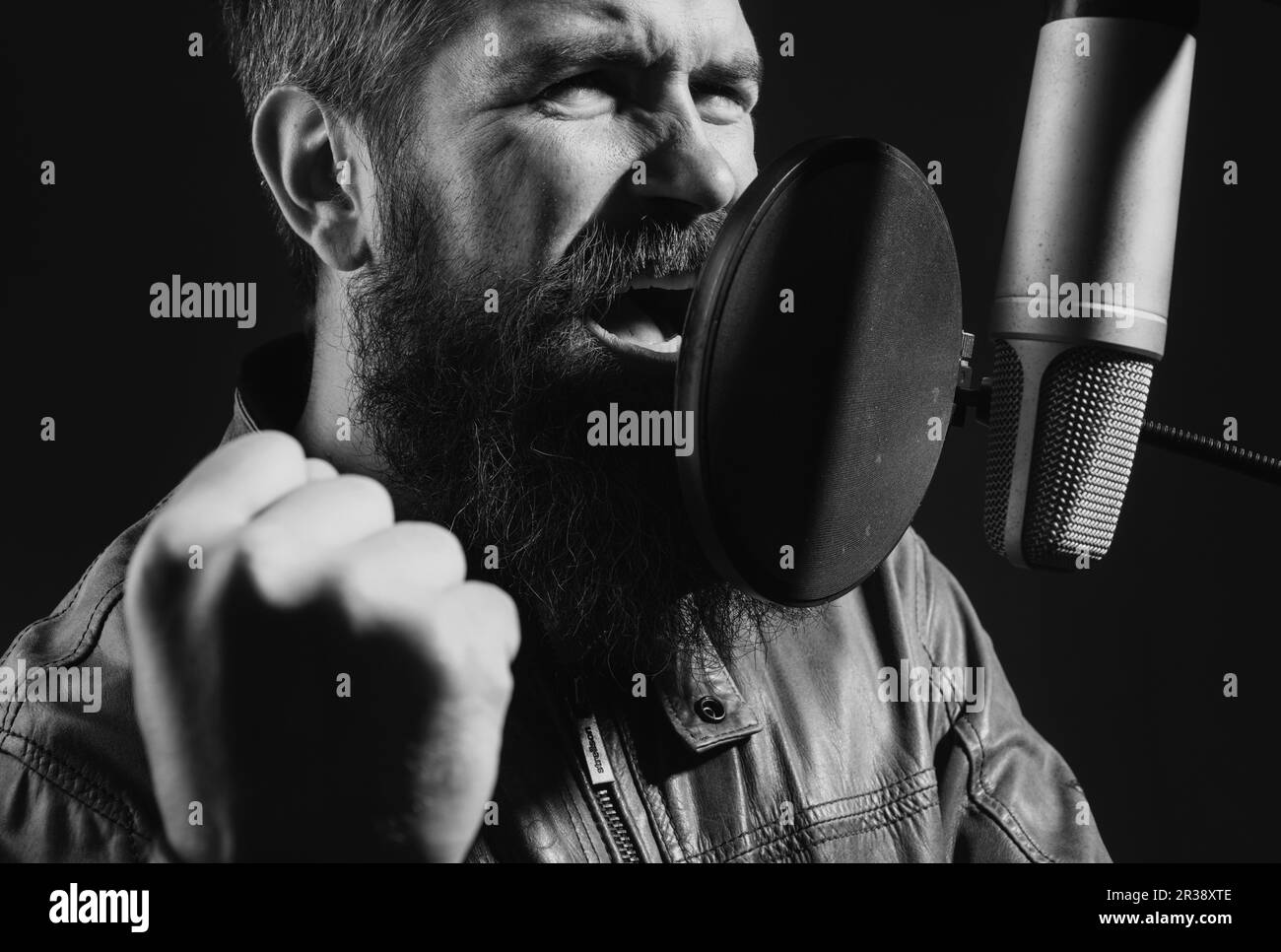 Singer wearing headphones is performing a song with a microphone while ...