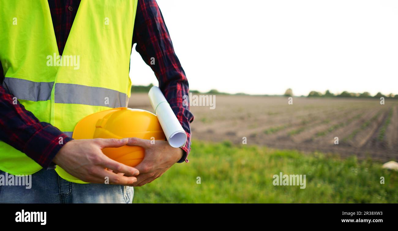 Construction worker holding his yellow helmet, hard hat and ...