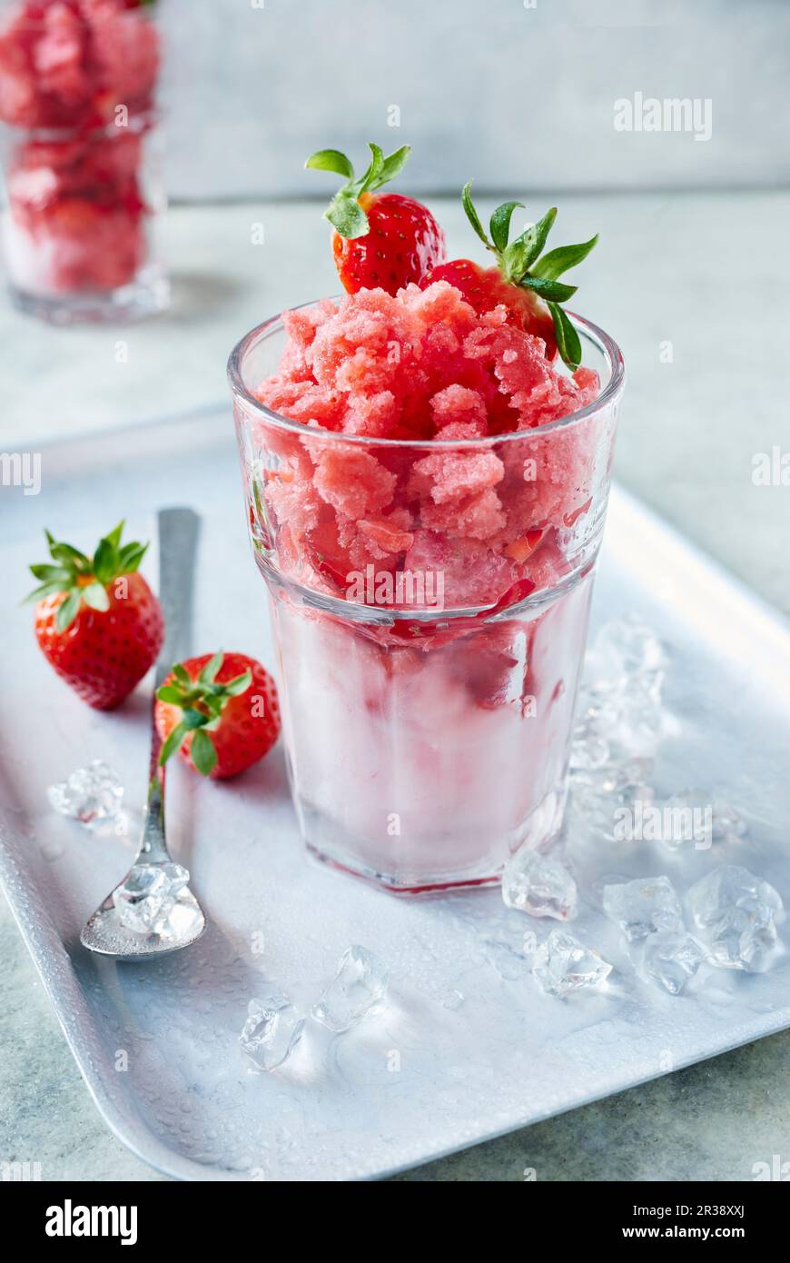 Strawberry granita in a cocktail glass with fresh strawberries and ice ...