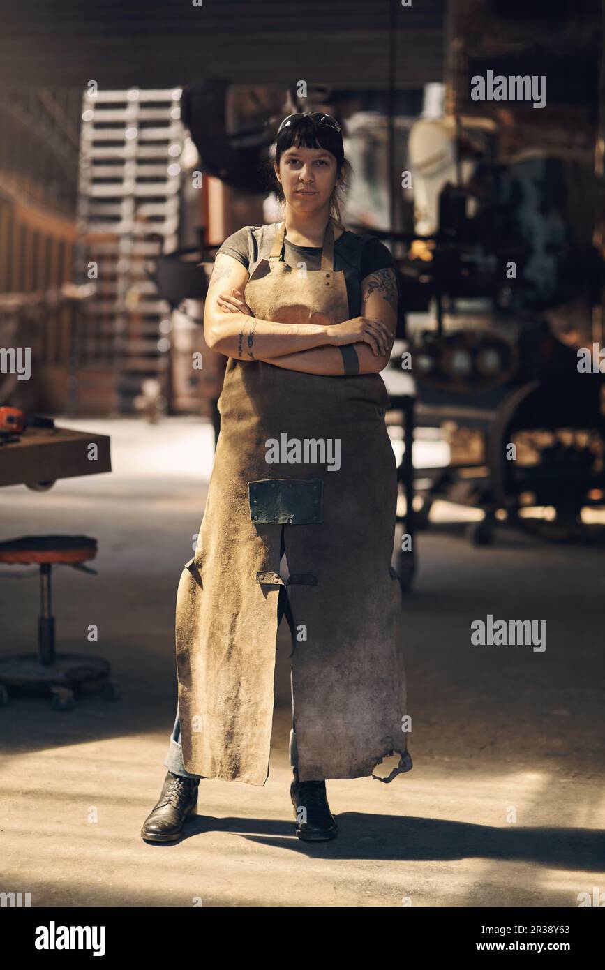 Blacksmith, workshop and portrait of woman with crossed arms for ...