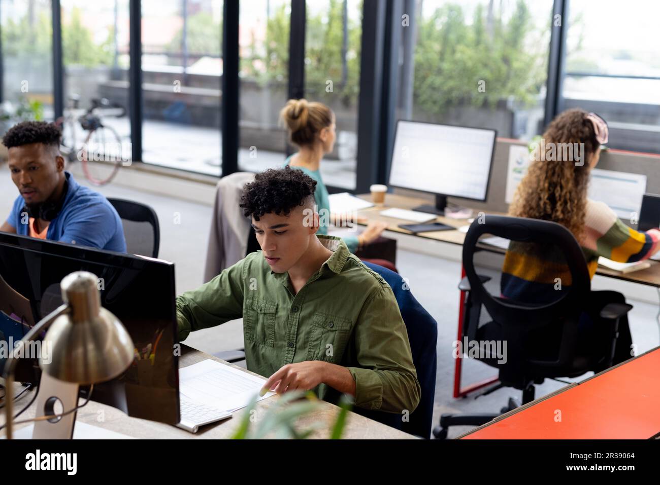 Busy diverse business people working at desks using computers in ...