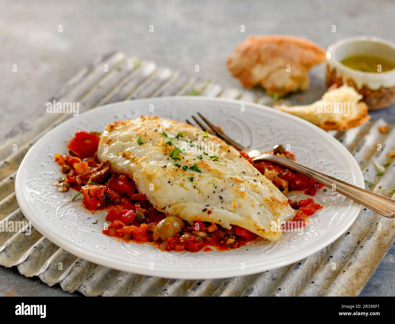 Cod fillets on tomato and olive salsa Stock Photo - Alamy