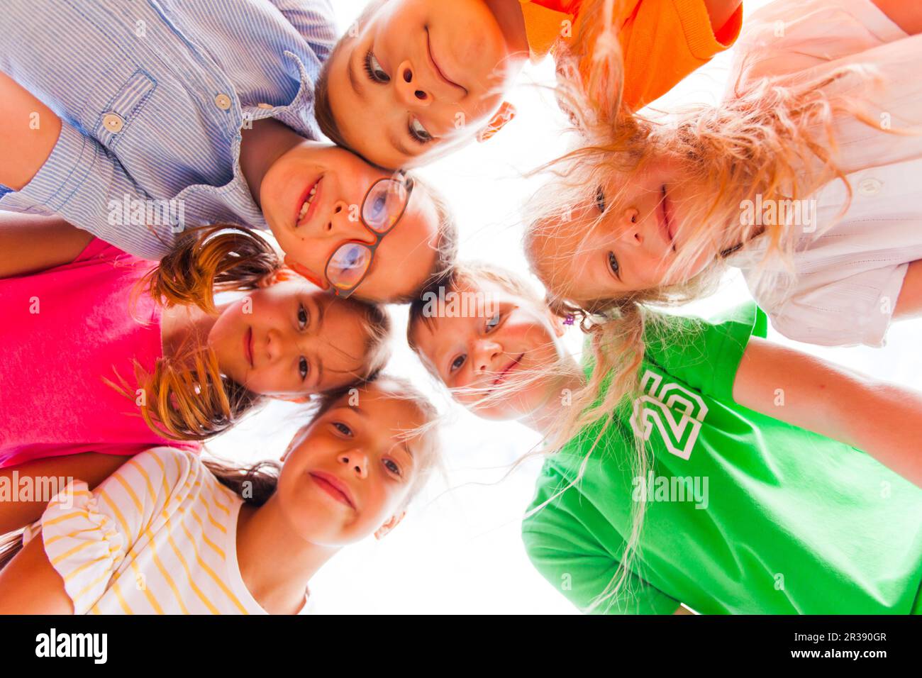 Cheerful kids standing closely in a circle touching their heads Stock ...